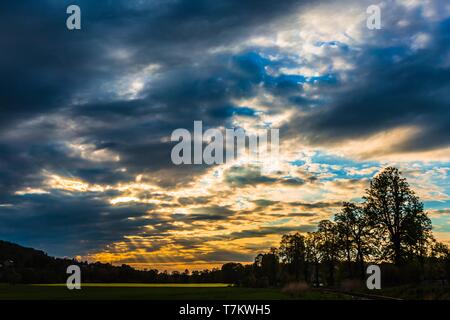 A scenic view of sunlight beaming through clouds above sea waves Stock ...