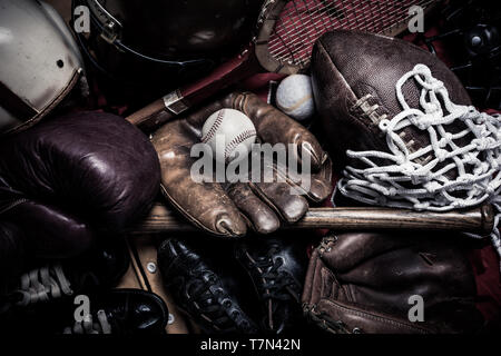 Assorted sports equipment including bat, baseball, football, soccer ...