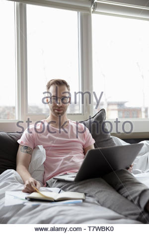 Man sitting working in home based IT computer office above garage in ...