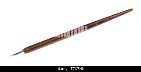 side view of brown wooden dip pen drawing a black line on sheet of ...