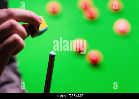 Male pool player chalking cue, close-up Stock Photo - Alamy