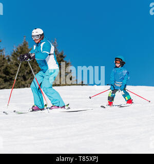Child learning how to ski with an instructor. Winter sport Stock Photo ...