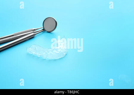 Dental instruments and occlusal splint on color background, closeup ...