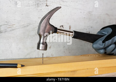 Black man hammering nail at construction site Stock Photo - Alamy