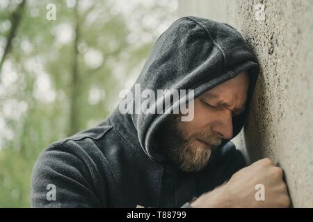 Man leaning head on hand, looking up, portrait Stock Photo - Alamy