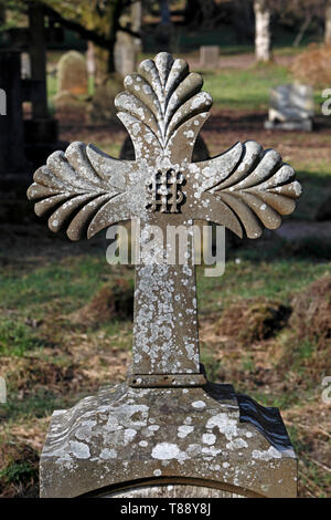 a headstone in a graveyard depicting jesus christ on a cross during the crucifixion Stock Photo ...