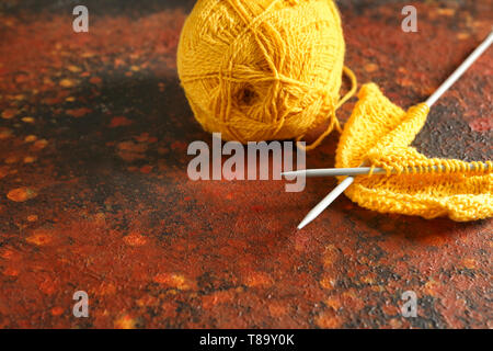 Color knitting yarn with unfinished clothes on table Stock Photo - Alamy