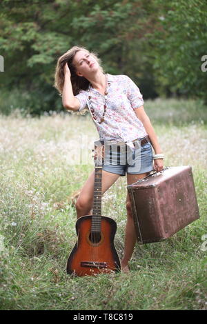 Beautiful hippie girl with guitar in park at sunset Stock Photo - Alamy