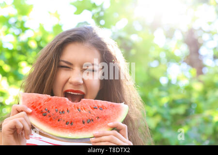 Emotional young woman with slice of tasty watermelon outdoors Stock ...