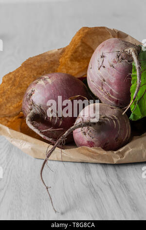 Organic beetroot in a brown paper bag on grey wood. Recycle packaging ...