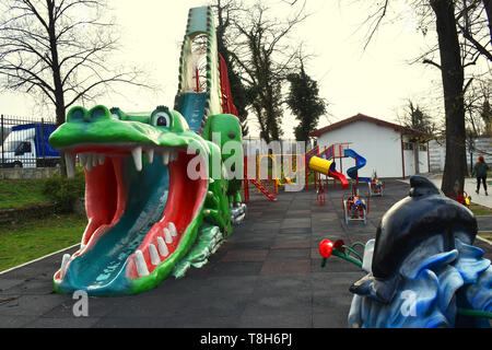 Green dinosaur slider in the park's playground Stock Photo - Alamy
