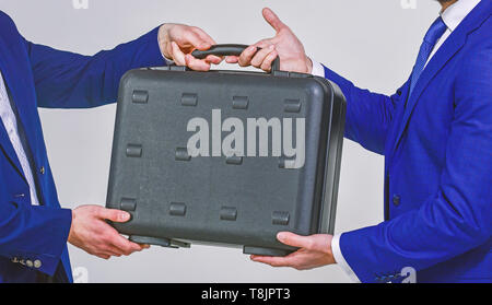 Business transfer deal. Handover of black suitcase in hands of partners ...