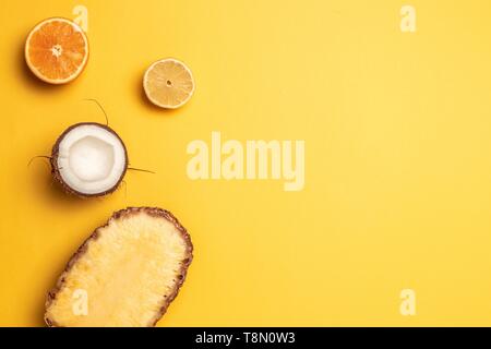 Tropical pineapple, oranges, lemon and coconut on a pastel background ...