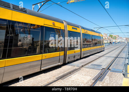 Modern light rail tram over the Dom Luis bridge in Porto city, Portugal ...