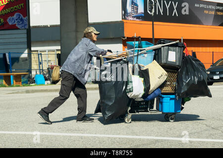 homeless man walking with shopping cart on sidewalk in San Francisco CA ...