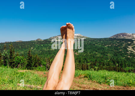 Female feet up infront of the clear blue sky and mountains Stock Photo ...