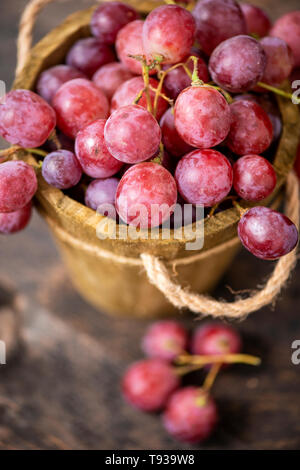 Rose grapes in wooden bucket on a woden table Stock Photo - Alamy
