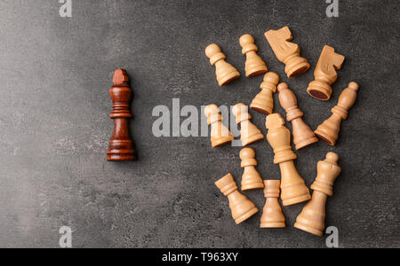Different chess pieces on grey table against dark background Stock ...