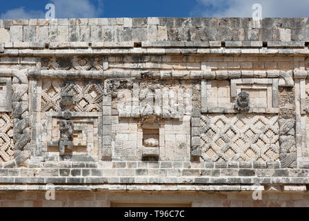 Close up of ancient Mayan carvings depicting heads and geometric shapes ...