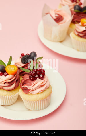 Two tasty cupcakes with fruits on wooden background Stock Photo - Alamy