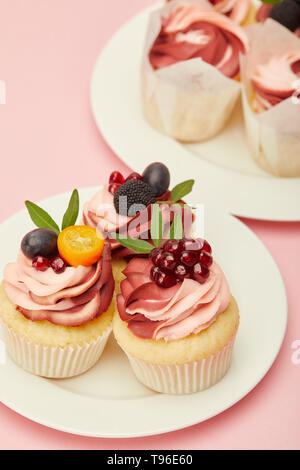 Two tasty cupcakes with fruits on wooden background Stock Photo - Alamy
