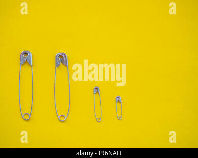 Several safety pins of various sizes in human representation. Concept ...