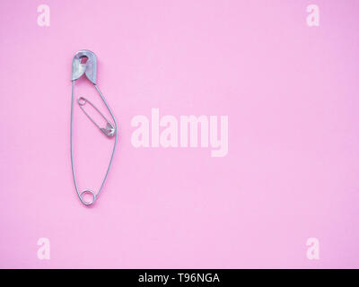 A safety pin representing a pregnant woman with a baby Stock Photo - Alamy