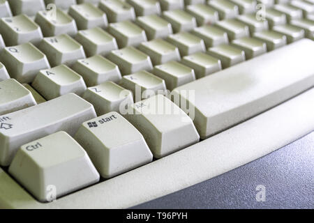 Windows start button of a keyboard in front of a window on a red ...