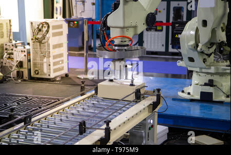 Robot arm loading carton on conveyor in manufacturing production line ...