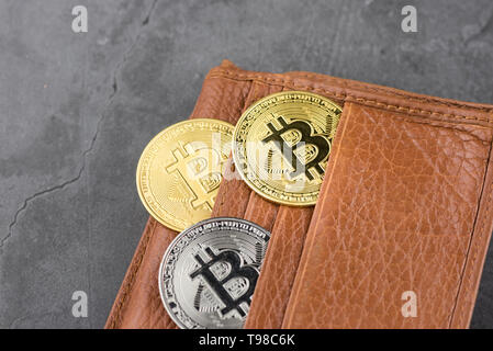View of metal bitcoins in brown leather wallet.Concept image for ...
