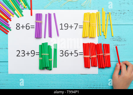 kid doing addition equation using counting rods Stock Photo - Alamy