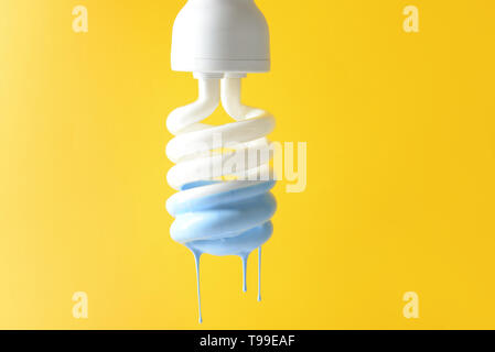 Paint dripping from light bulb on color background Stock Photo - Alamy