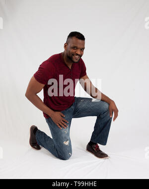 Happy Black Man Kneeling Stock Photo - Alamy