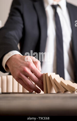 Close-up Of Businessman Stopping The Effect Of Domino With Hand Stock ...