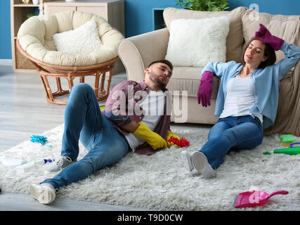 Tired couple resting after cleaning their flat Stock Photo - Alamy