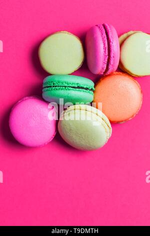 Many colored french macaroons or macaroon on a wooden tray a jar of ...