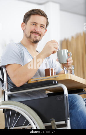 a delighted disabled man eating Stock Photo - Alamy