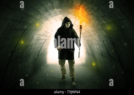Ugly man with burning flambeau walking in a dark tunnel Stock Photo - Alamy