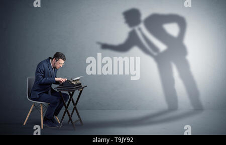 Little man working and a big shadow arguing with him Stock Photo - Alamy