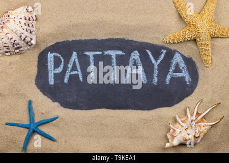 Handwritten word PATTAYA written in chalk, among seashells and ...