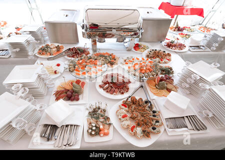 plates and a variety of dishes on the handout table in the restaurant ...