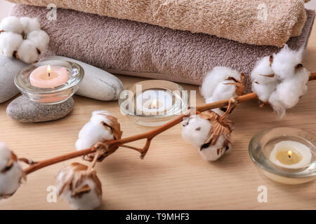 Burning candles and towels on table in spa salon Stock Photo - Alamy