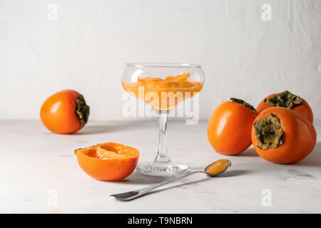 Glass with sweet persimmon jam on table, top view Stock Photo - Alamy