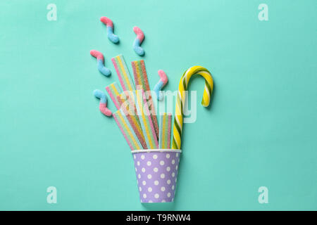 Cup with different tasty candies on color background Stock Photo - Alamy