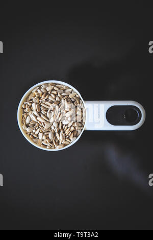Sunflower seeds without shell in a wooden scoop on a white background ...