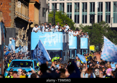 The Manchester City players and staff on the buses pass the crowds of ...