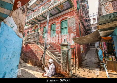 Varanasi narrow alleyway with old residential buildings. Varanasi is ...