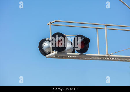 high level railroad crossing lights and barriers against blue sky ...