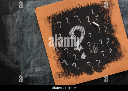 Sketched question marks on cardboard paper, concept of perplex and ...