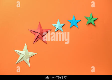 Origami stars on color background, sparkling stars on a orange ...